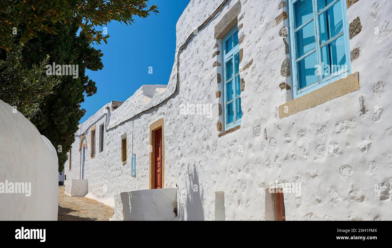 Row of white houses with blue windows under a blue sky, traditional ...