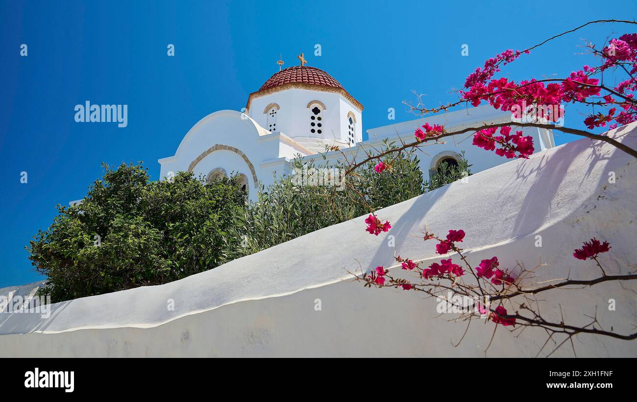 A white wall with a view of a church with a red dome and colourful ...