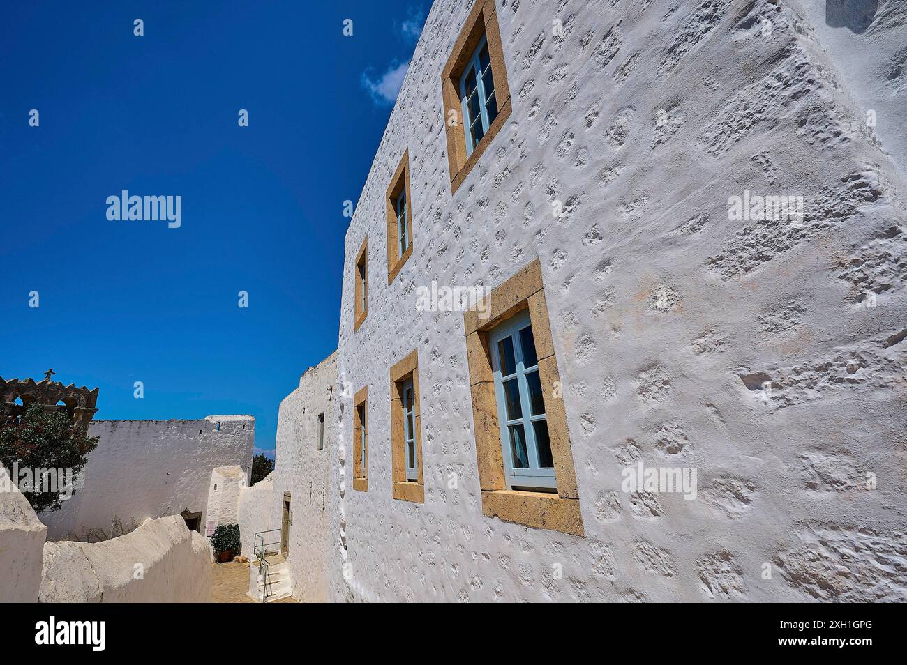 White facade of a historic building with bright windows under a clear ...