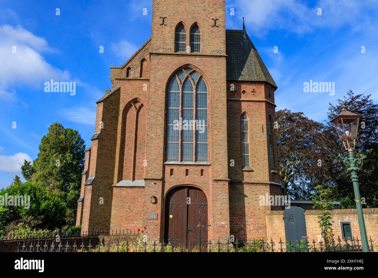 Front view of a gothic brick church with large windows and door ...