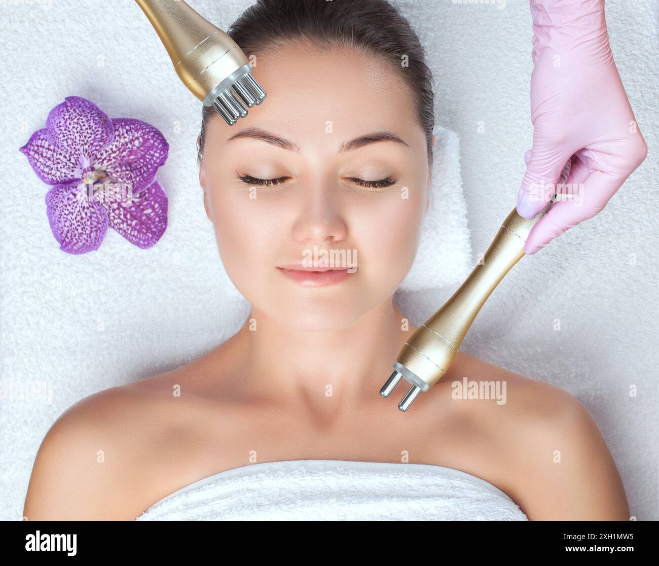 The cosmetologist does rf-lifting of the face skin of a beautiful woman ...