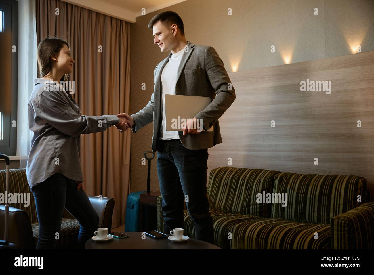 Young entrepreneurs greeting one another in hotel room Stock Photo - Alamy