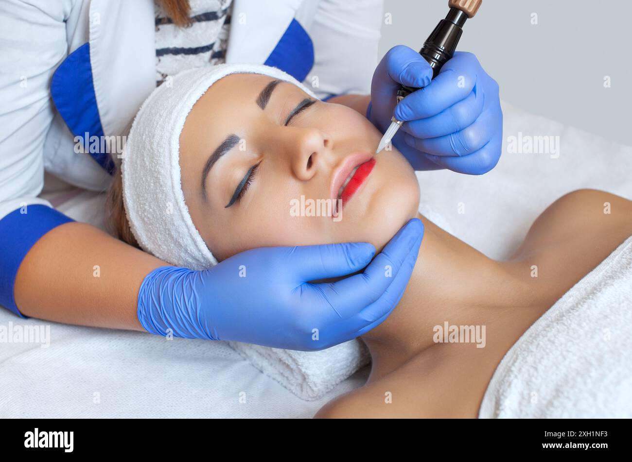 Permanent make-up for lips of beautiful woman in beauty salon. Closeup ...