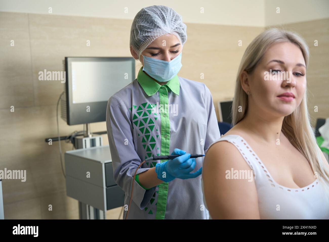 Healthcare professional removing patient skin lesion during ...