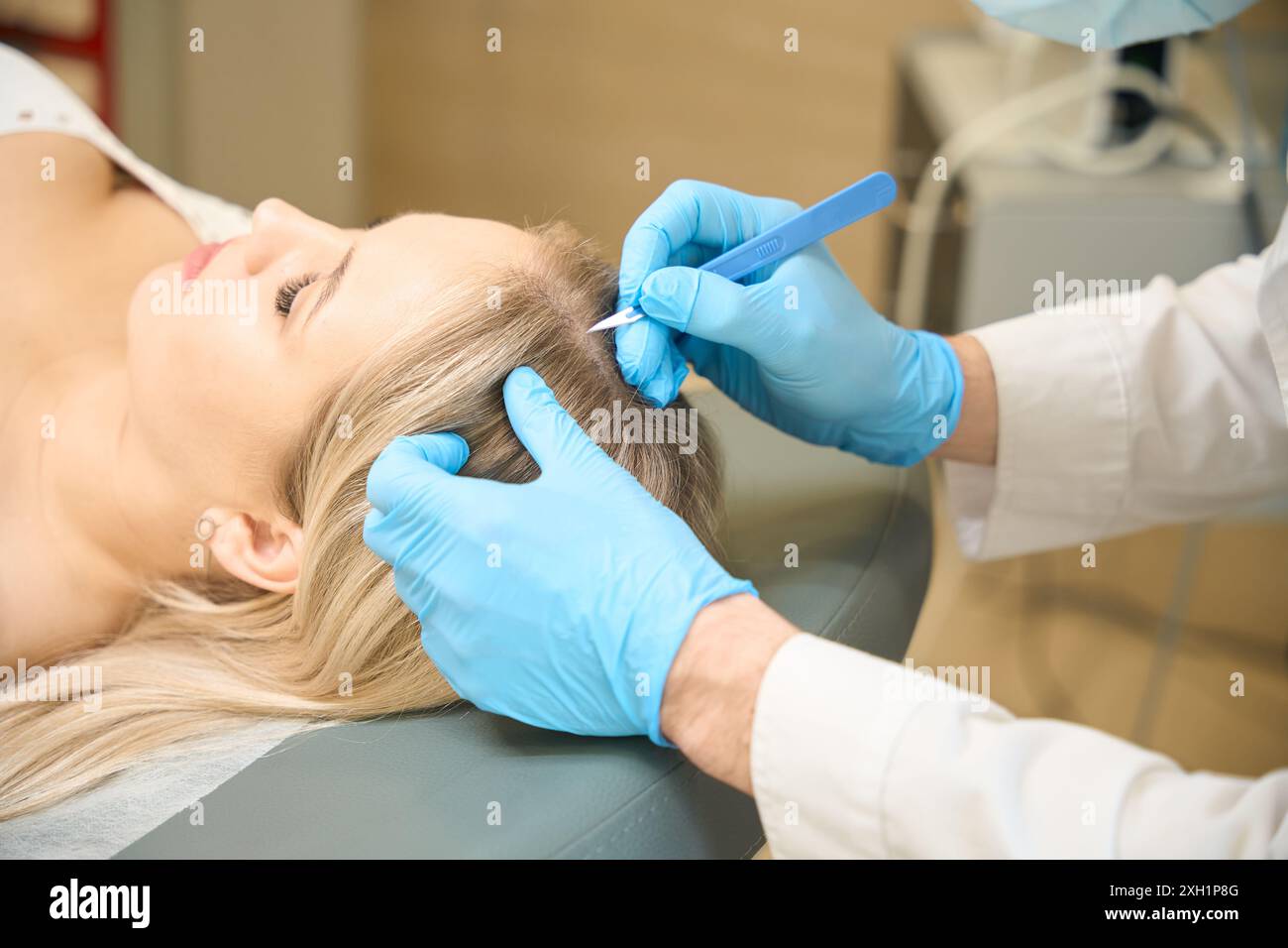 Dermatologist performing surgical removal of sebaceous cyst on client ...