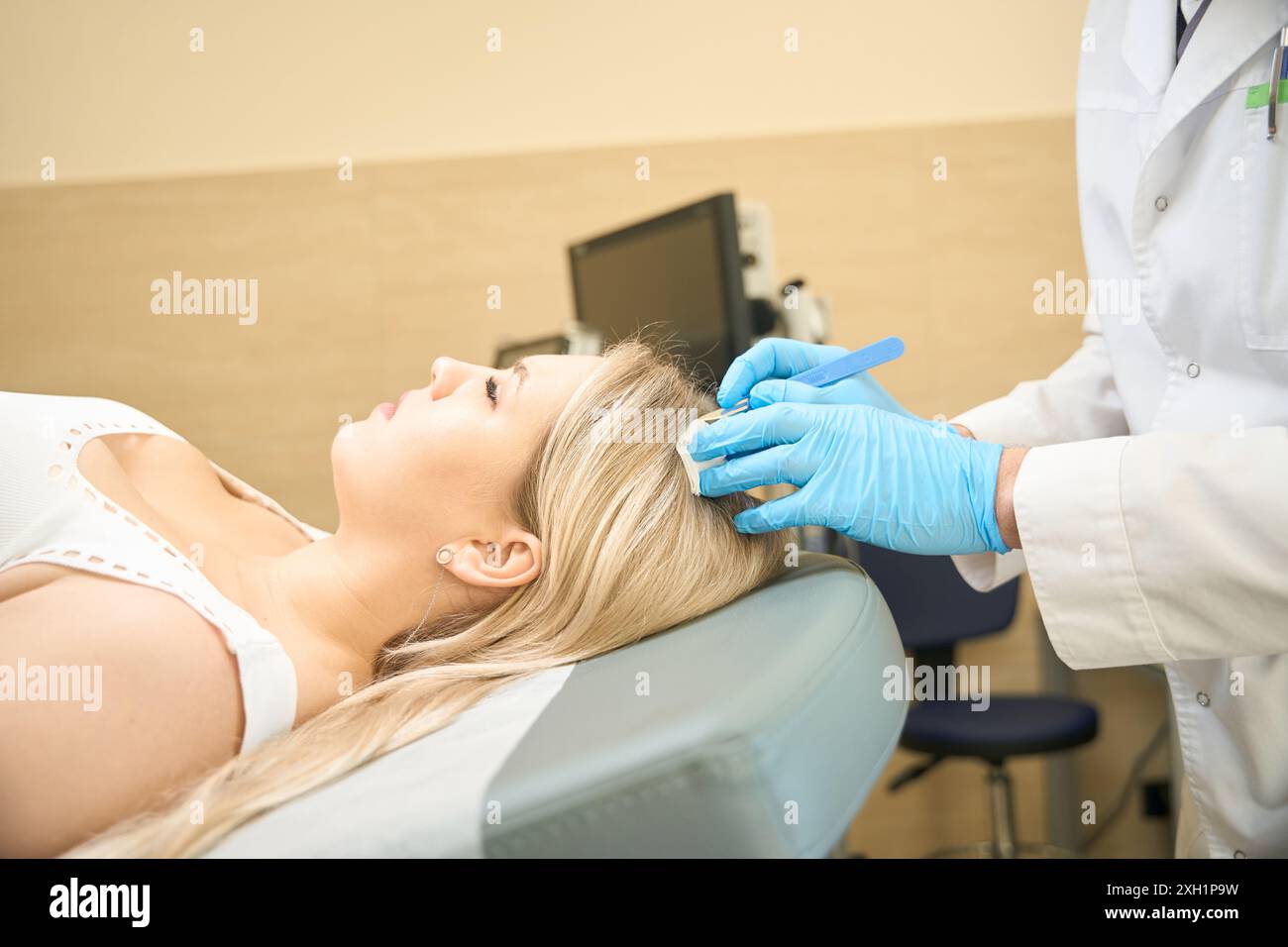 Dermatologist performing surgical excision of sebaceous cyst on patient ...