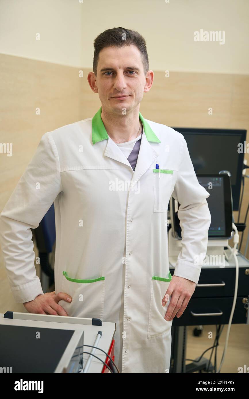 Ultrasonographer standing in examination room with ultrasonic medical ...