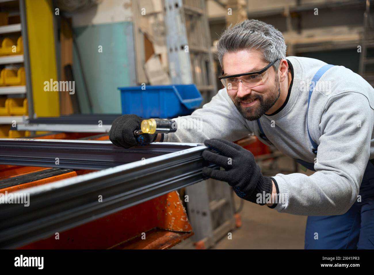Bearded employee works with window frame made of aluminum profile Stock ...