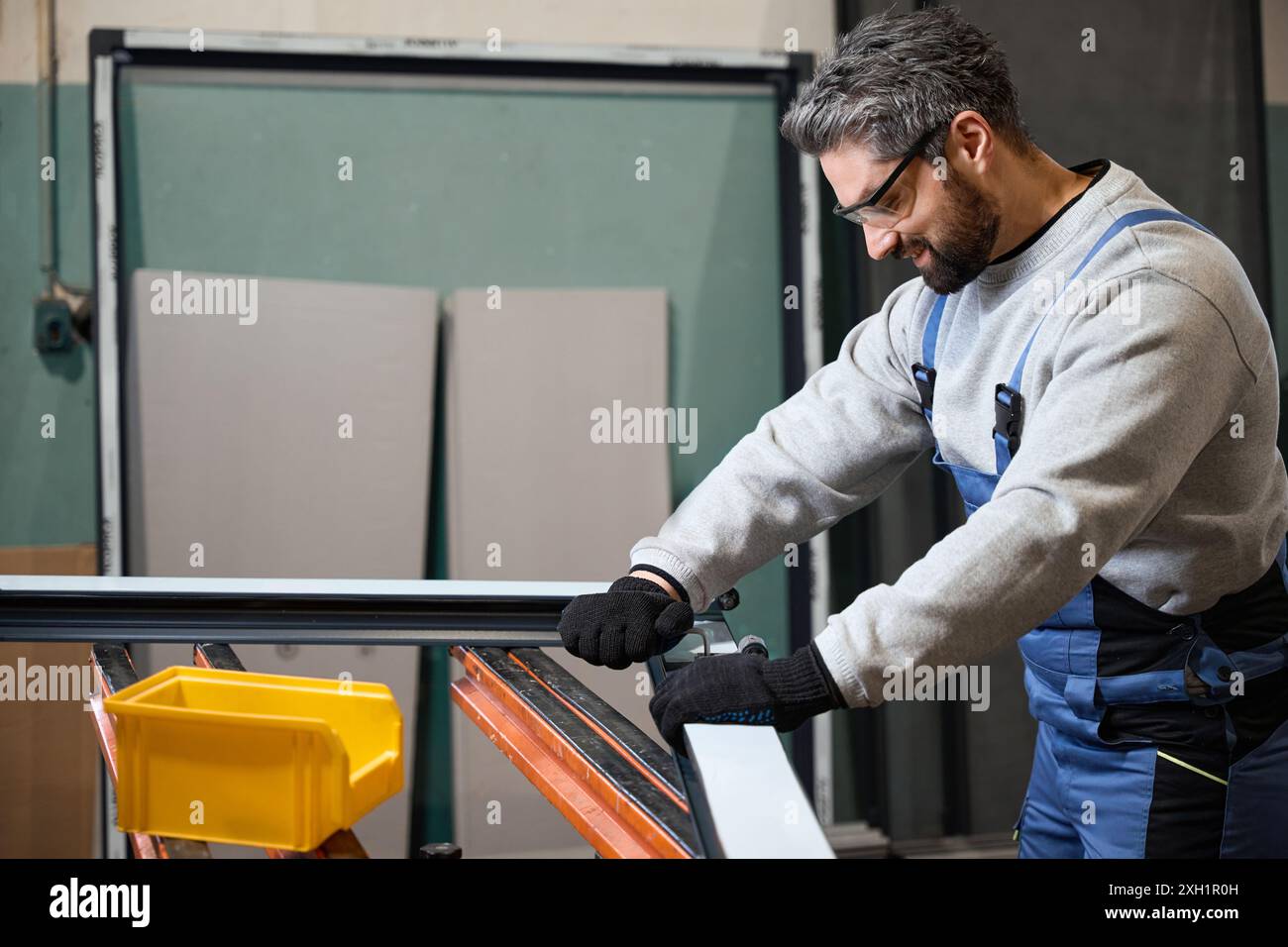 Middle-aged worker makes a window profile in the workshop Stock Photo ...