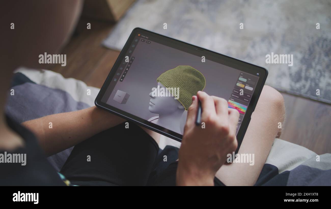 Boy with digital stylus and tablet in hands sits at home, creates 3d ...