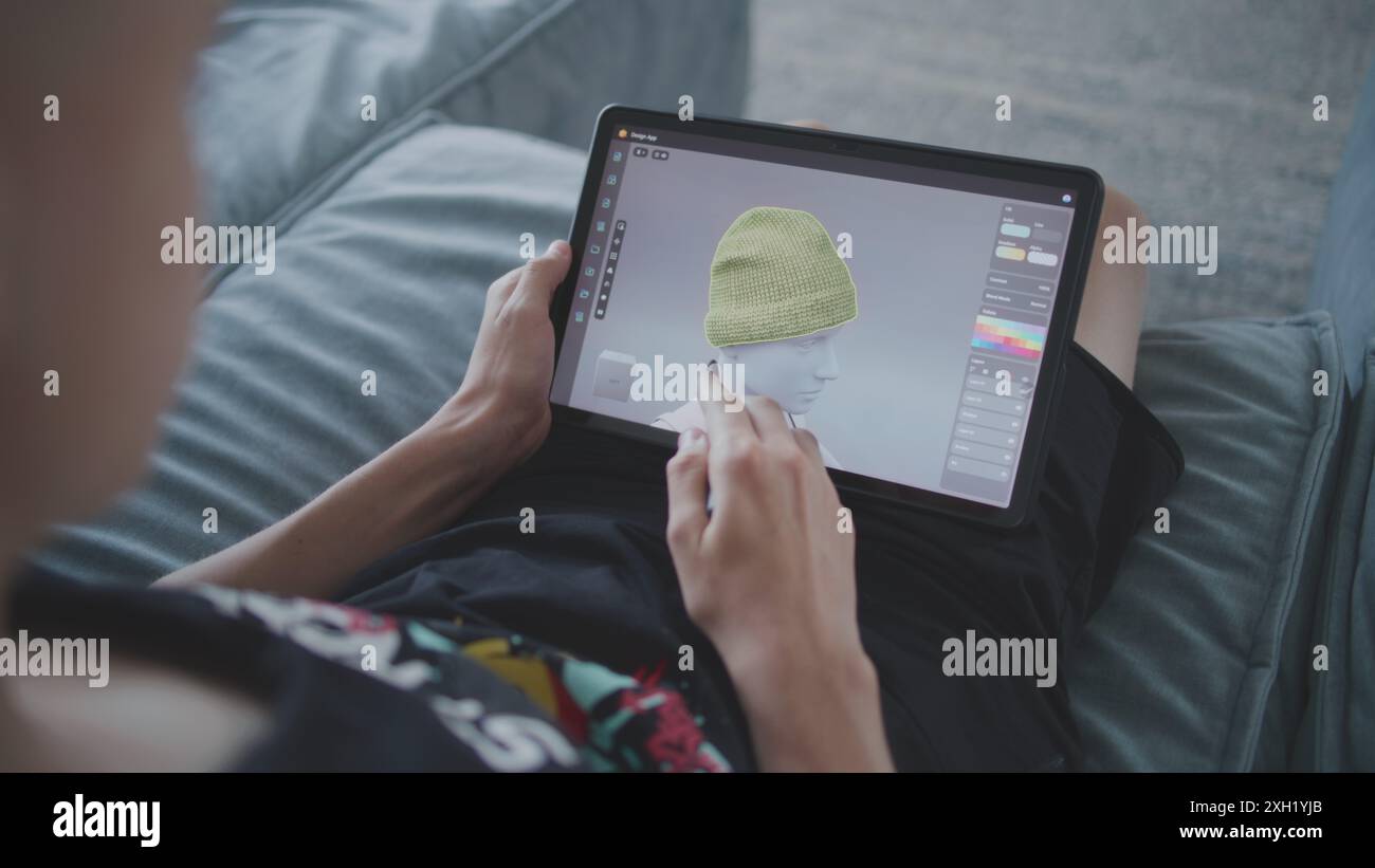 Boy with digital stylus and tablet in hands sits at home, creates 3d ...