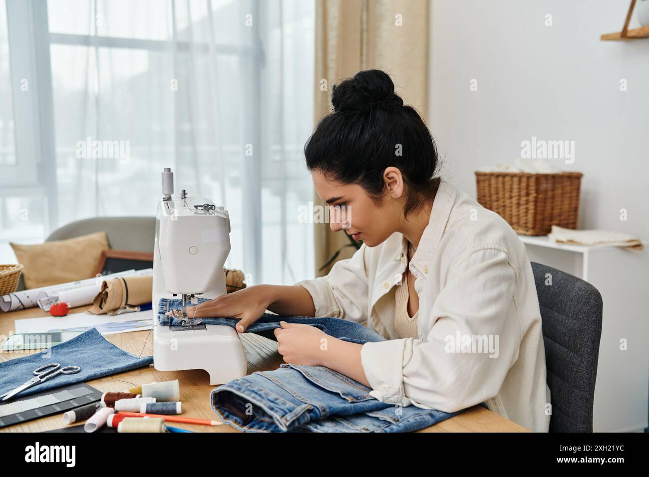 Young woman upcycling clothes using a sewing machine Stock Photo - Alamy