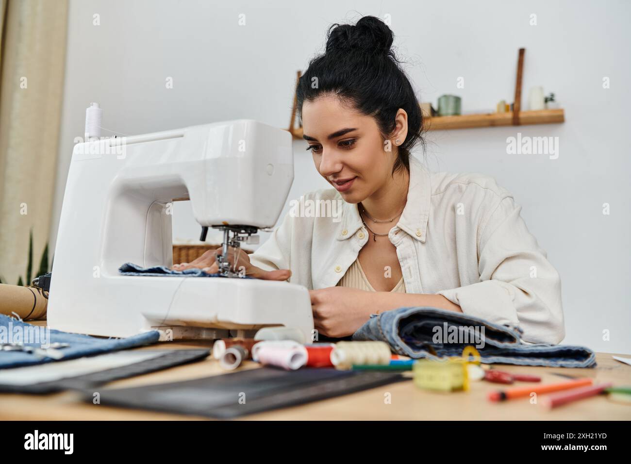 Young woman upcycles clothes at sewing machine Stock Photo - Alamy