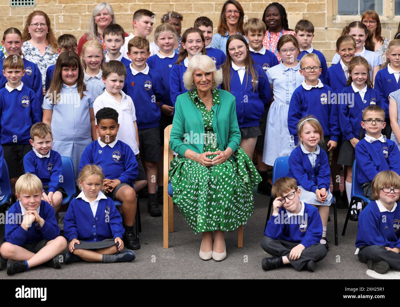 Queen Camilla poses for a photo with pupils during a visit to Lacock ...