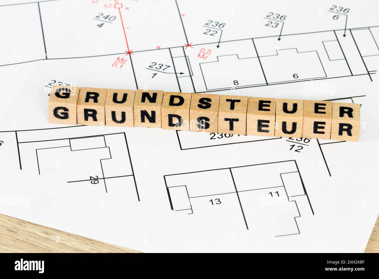 Symbol image of property tax: Letter cubes on a development plan show ...