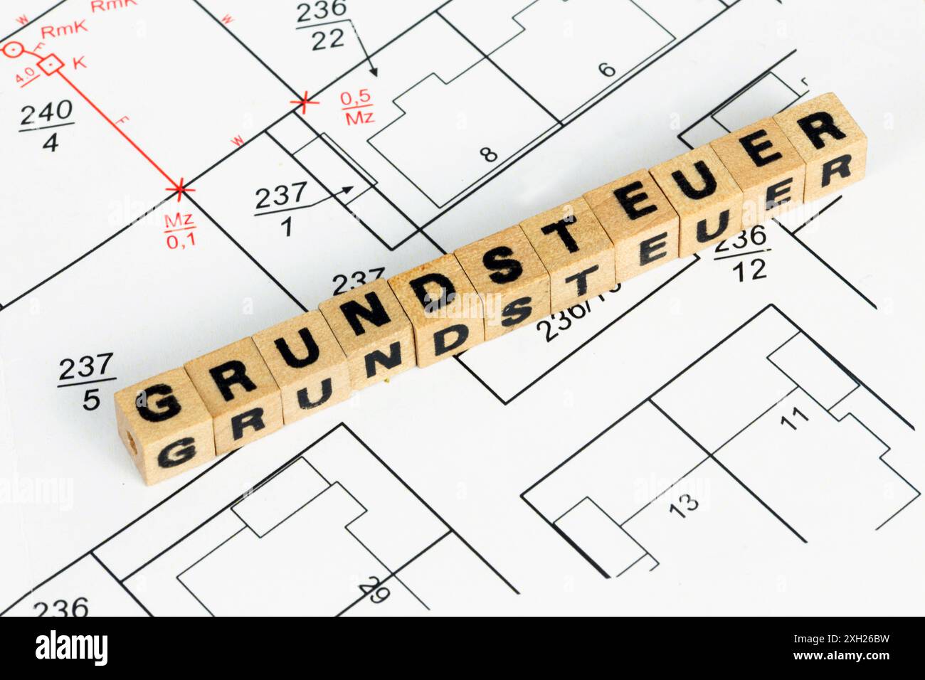 Symbol image of property tax: Letter cubes on a development plan show ...