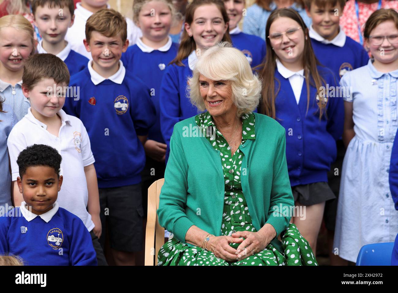 Queen Camilla poses for a photo with pupils during a visit to Lacock ...
