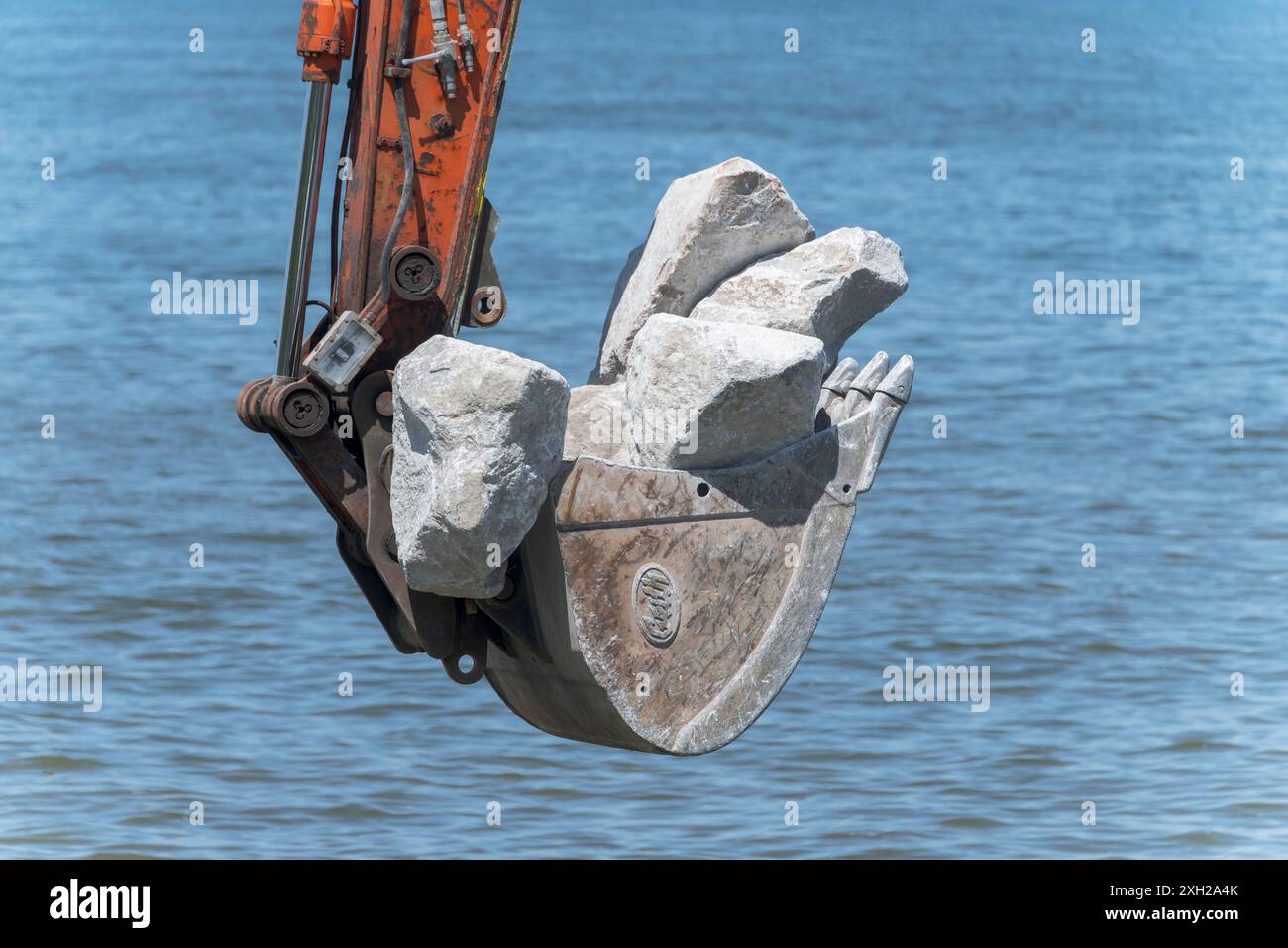 coastal erosion protection work with machinery from a barge at sea ...