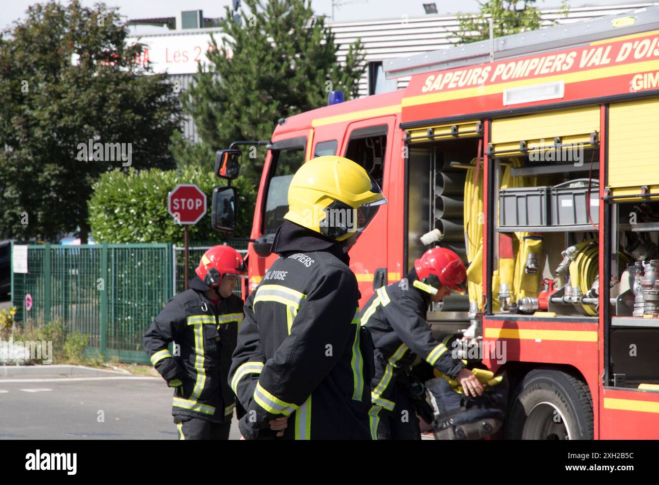 Val D'Oise France. Firefighters damping down potential dry grass ...