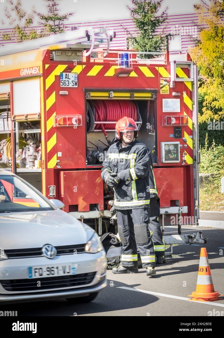 Val D'Oise France. Firefighters damping down potential dry grass ...