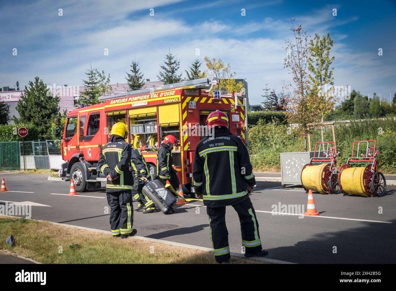 Val D'Oise France. Firefighters damping down potential dry grass ...