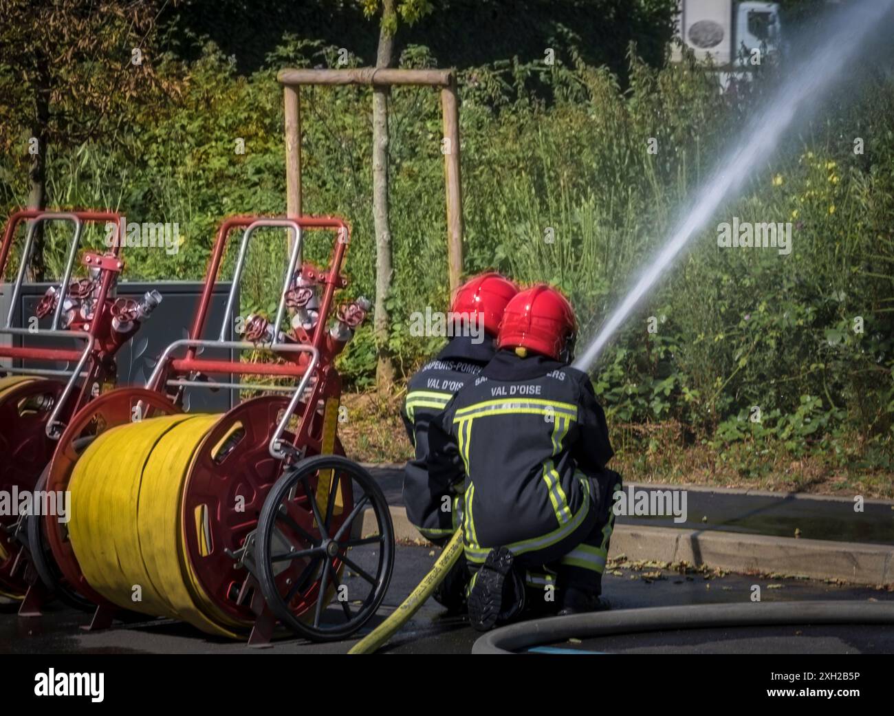Val D'Oise France. Firefighters damping down potential dry grass ...