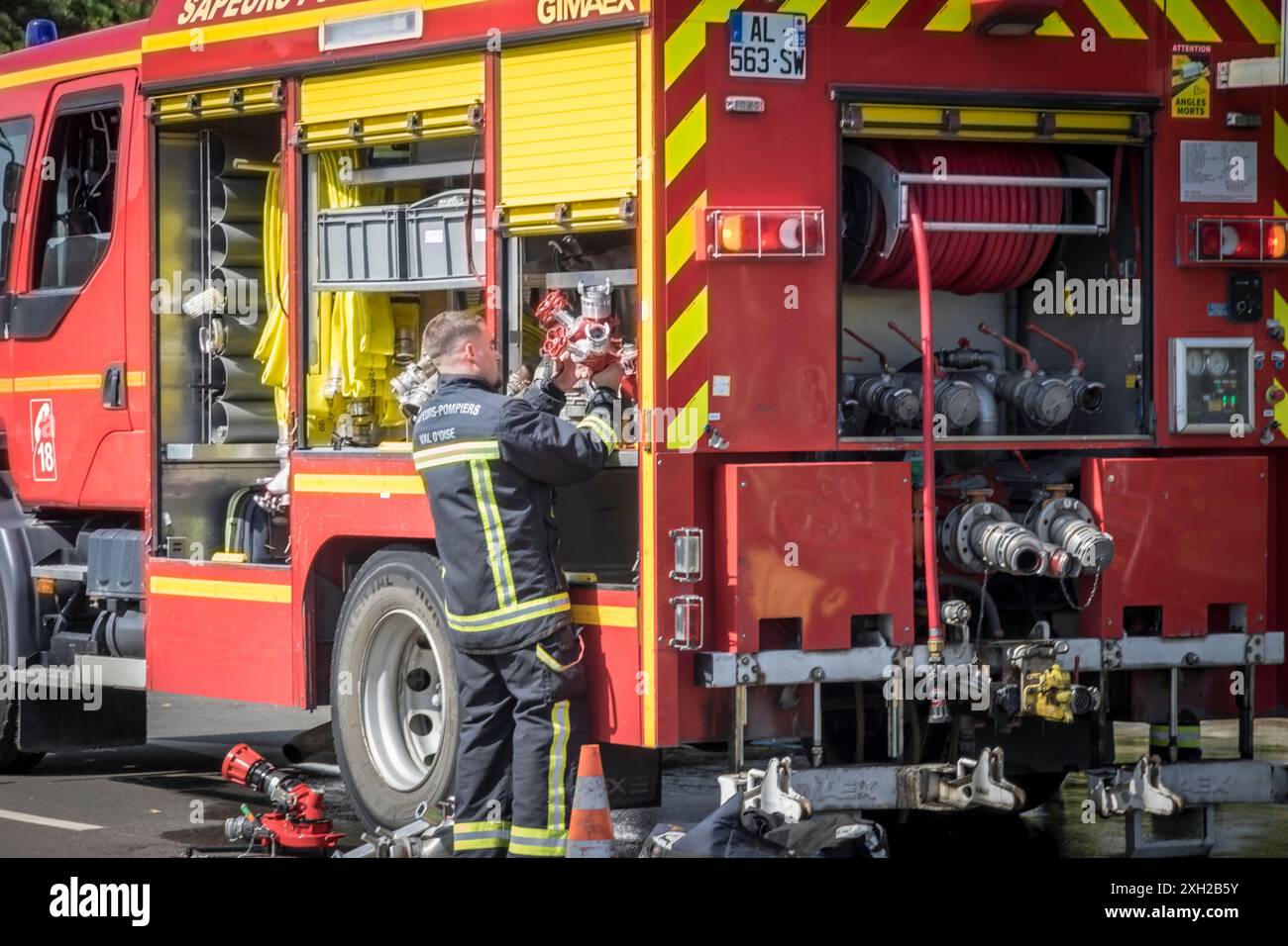 Val D'Oise France. Firefighters damping down potential dry grass ...