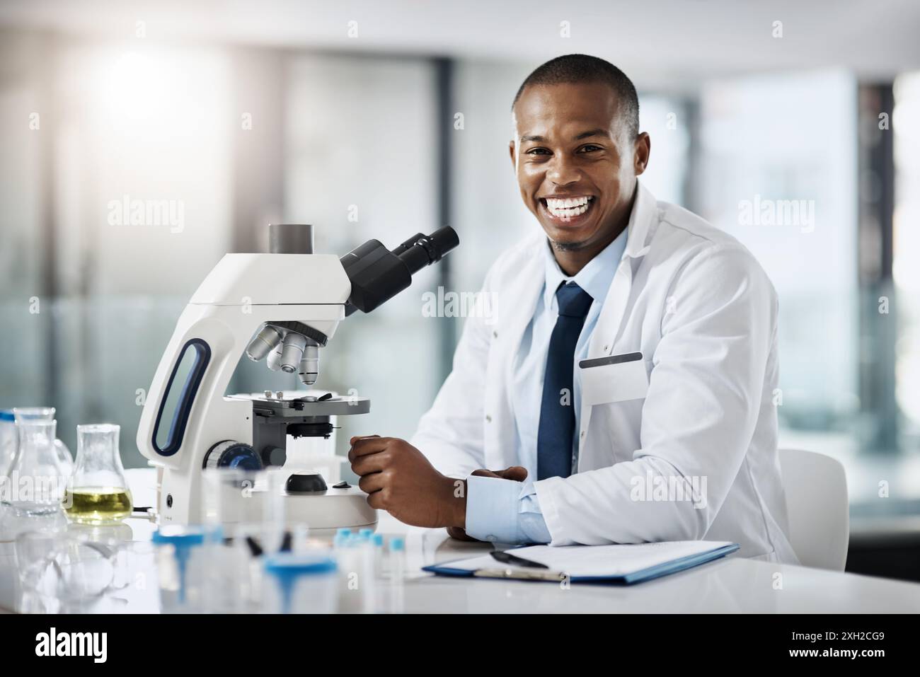 Smile, science and portrait of black man with microscope, medical study ...