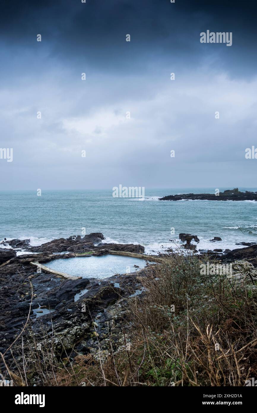 The large shallow historic tidal pool on the rocky shore in Mousehole ...