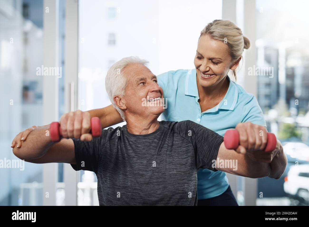 Physical therapy, dumbbell and senior patient with support, help or ...