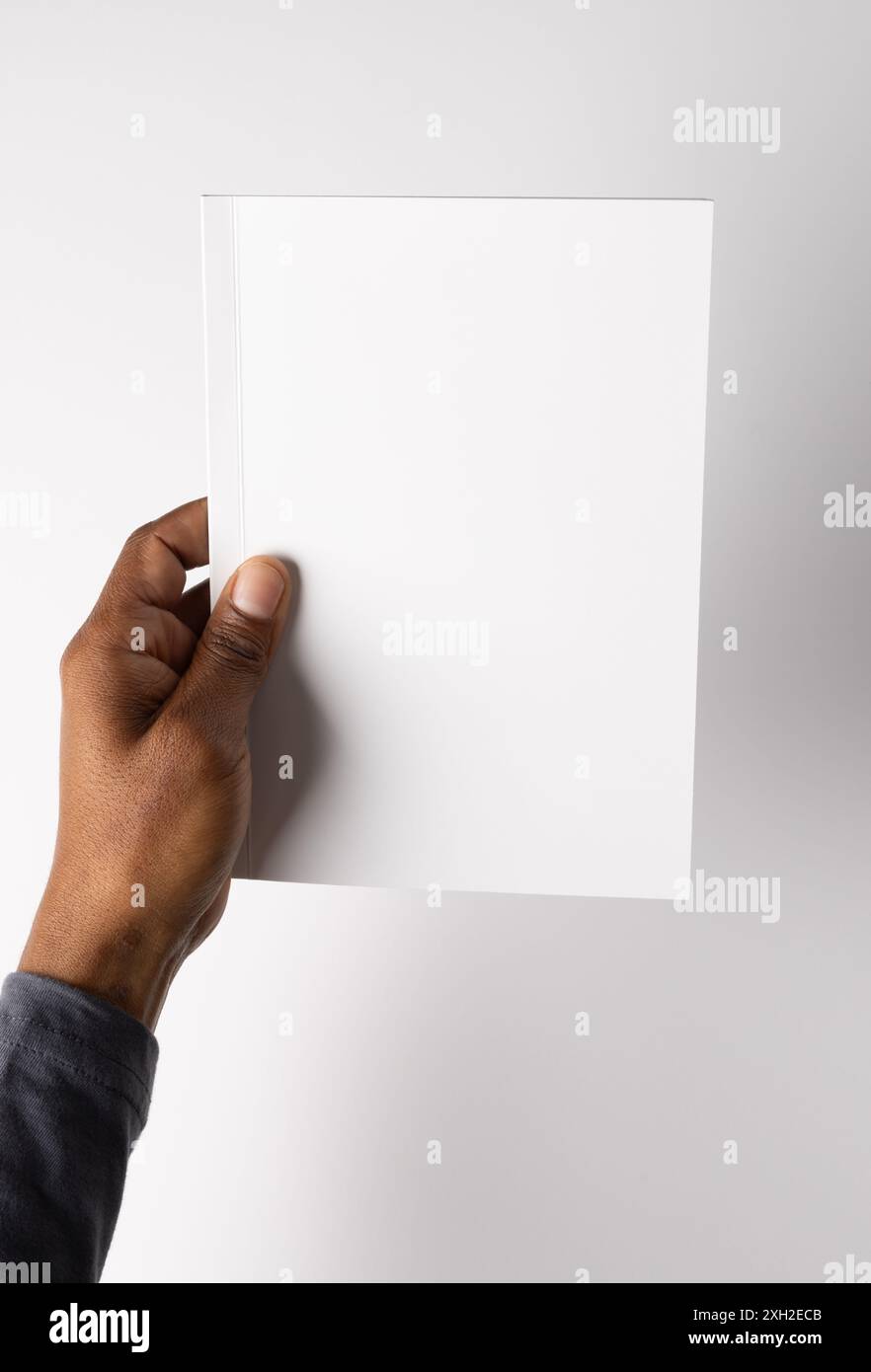 Biracial hand holding a blank white paper, with copy space. Ideal for a ...