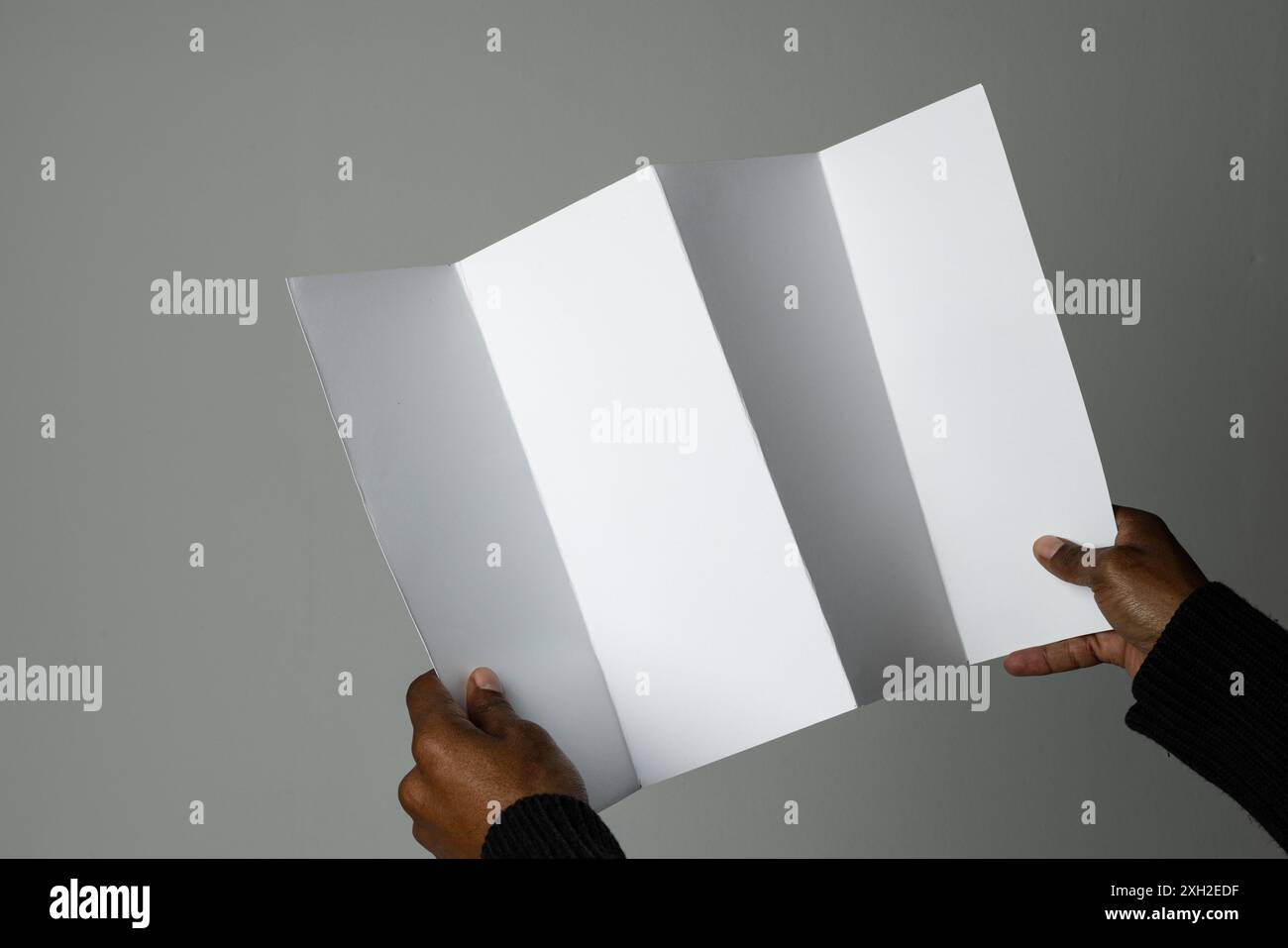 Hands of an African American man holding a blank brochure, with copy ...