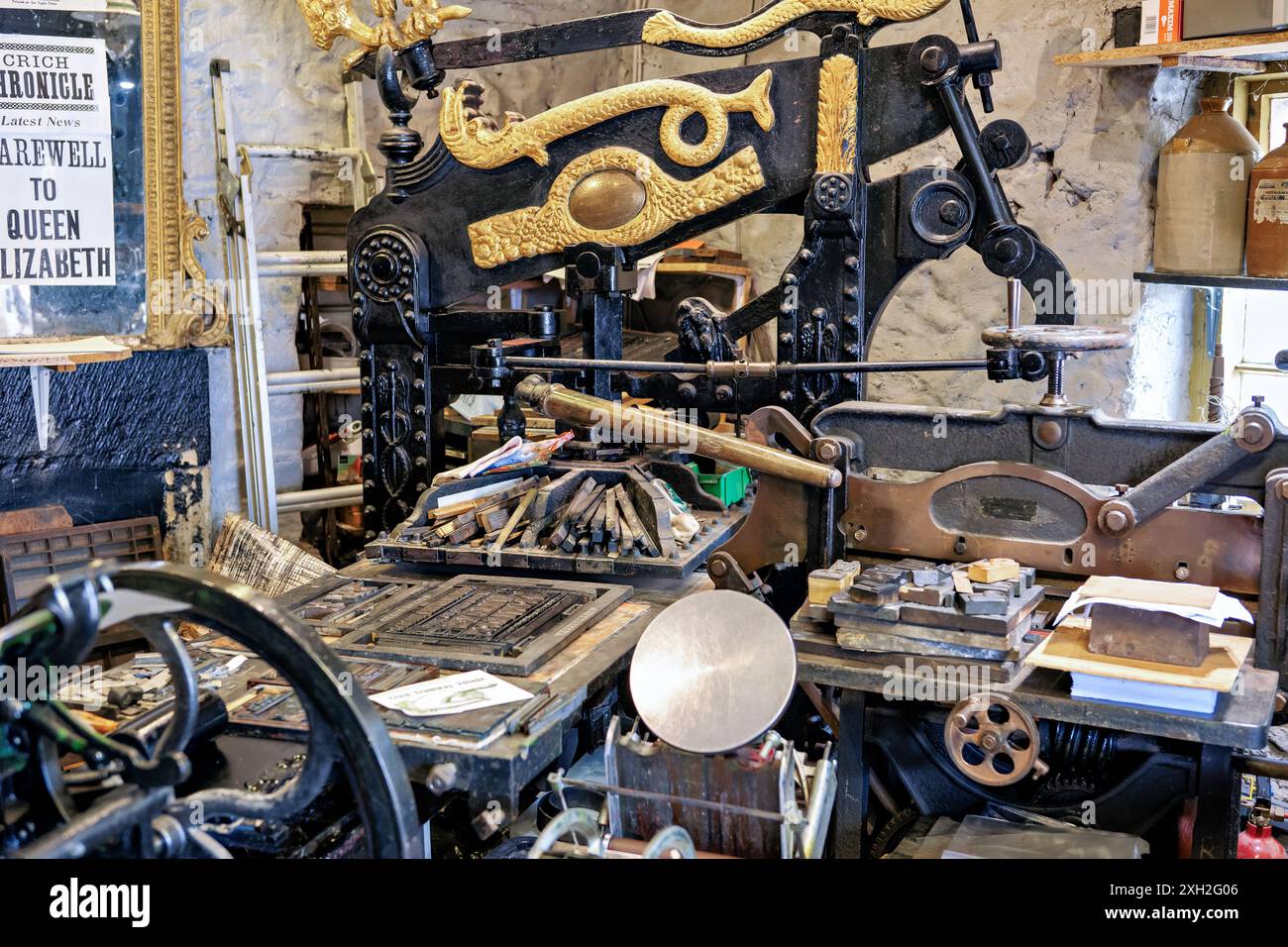 Antique printing press in a historical workshop filled with tools ...