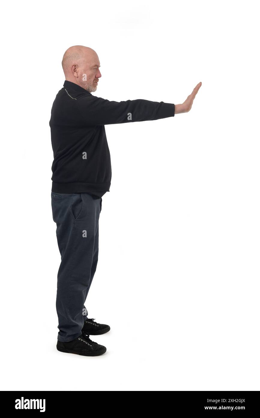 side view of a man showing the stop sign with their hands on white ...