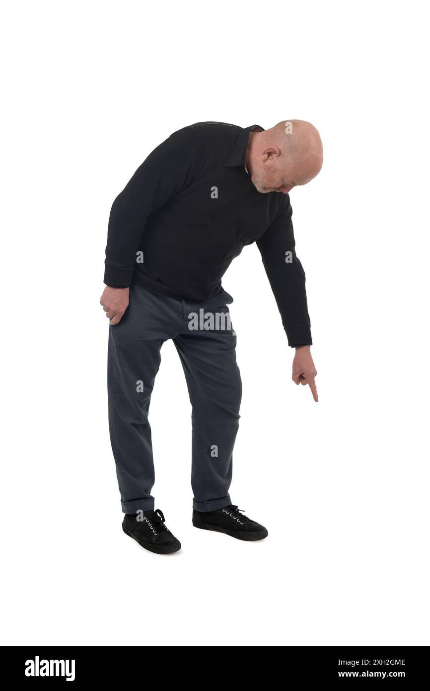 side view of a man pointing finger at the ground on white background ...