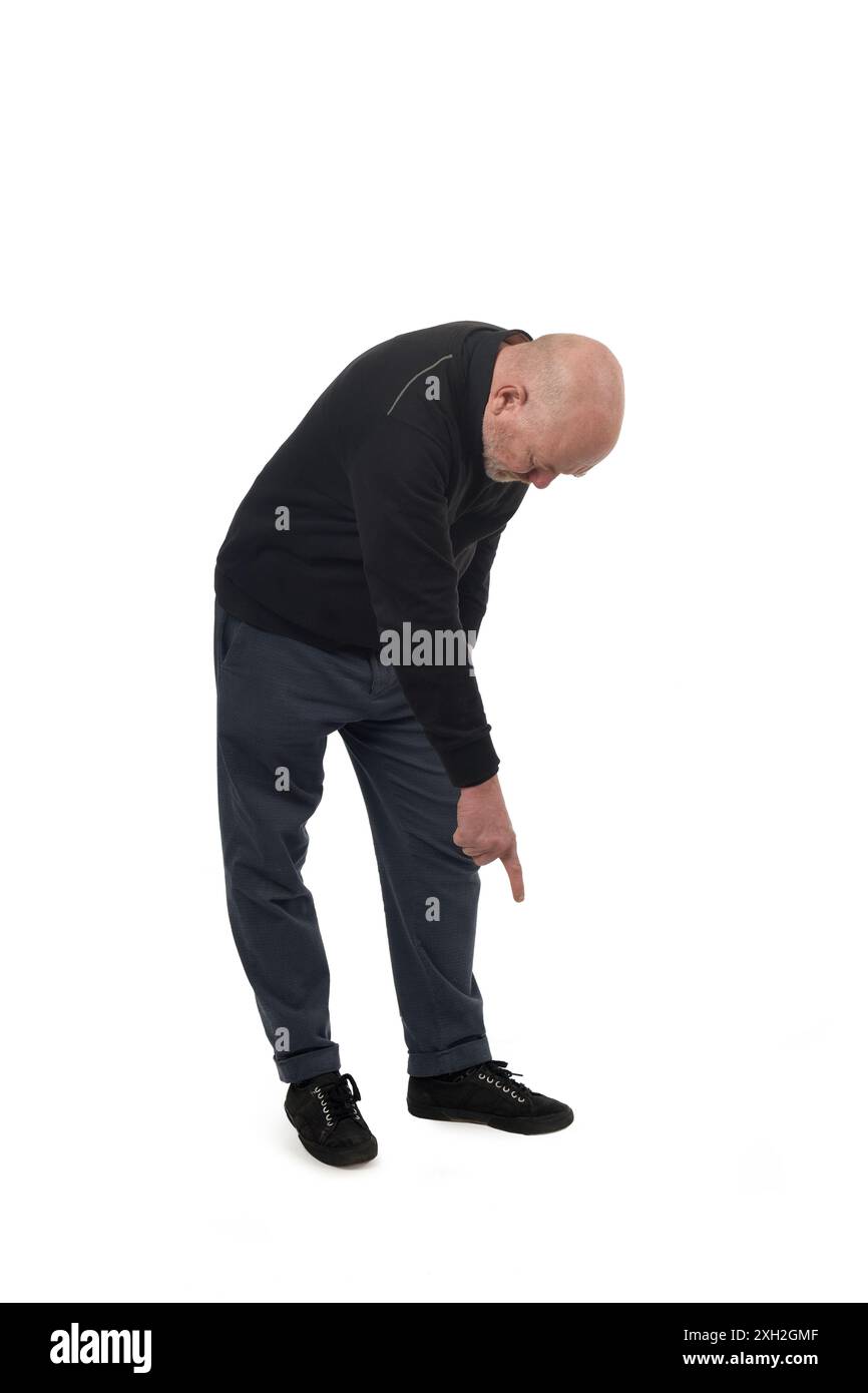 side view of a crouching man pointing finger at the ground on white ...