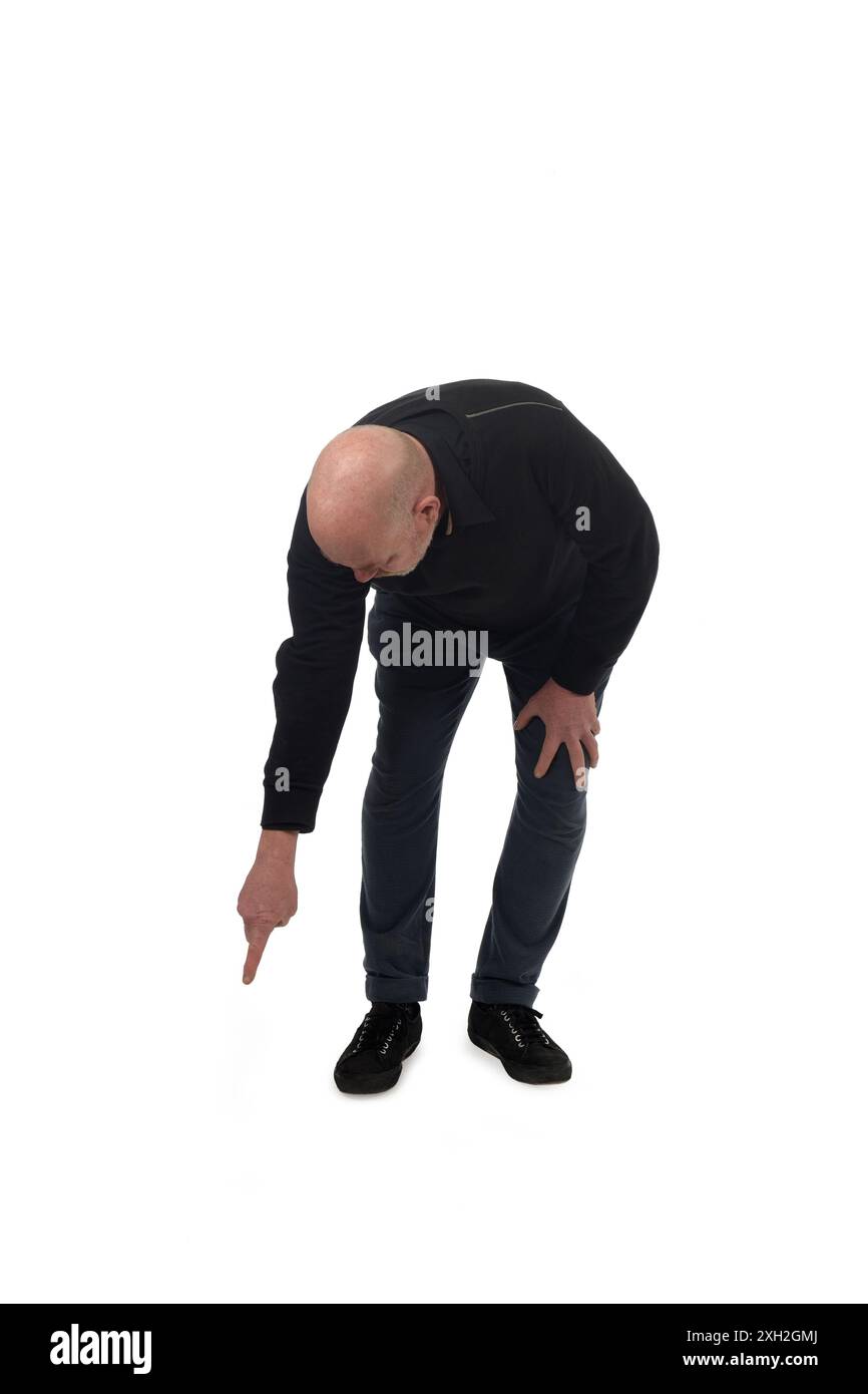 front view of a crouching man pointing finger at the ground on white ...