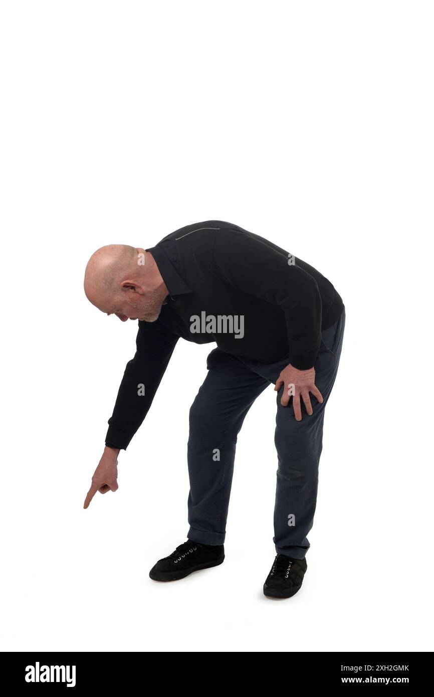 side view of a crouching man pointing finger at the ground on white ...