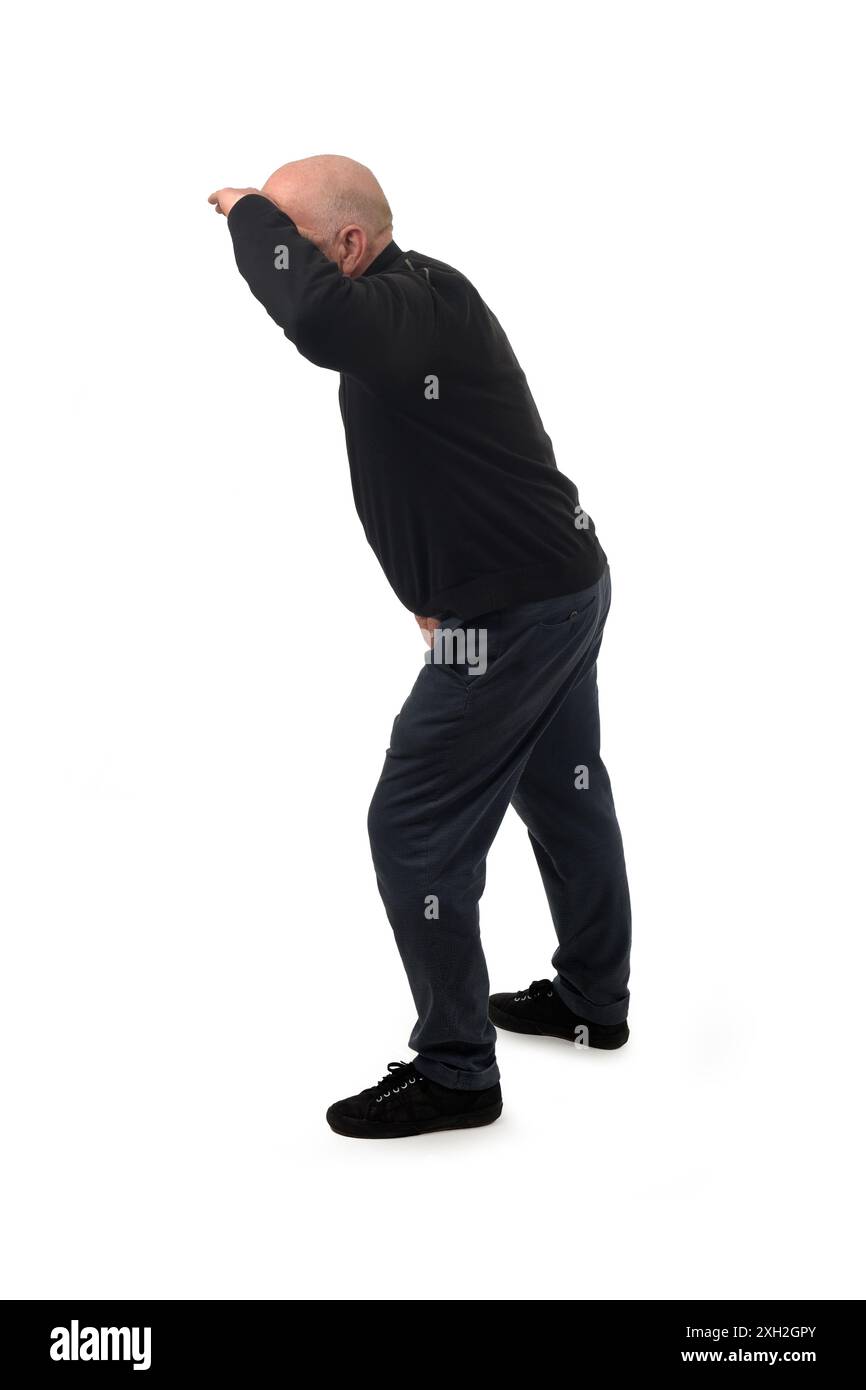 side view of a man with his hand on his forehead looking into the ...