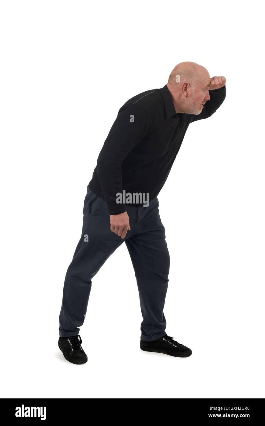 side view of a man with his hand on his forehead looking into the ...