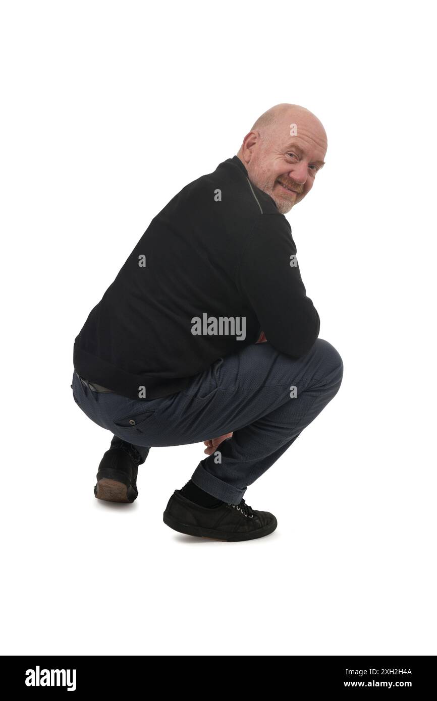 back view of a squatting man looking at camera on white background ...