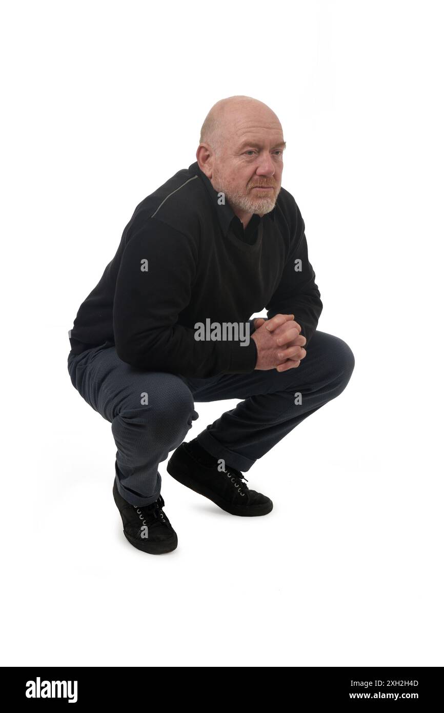 squatting man looking away on white background Stock Photo - Alamy