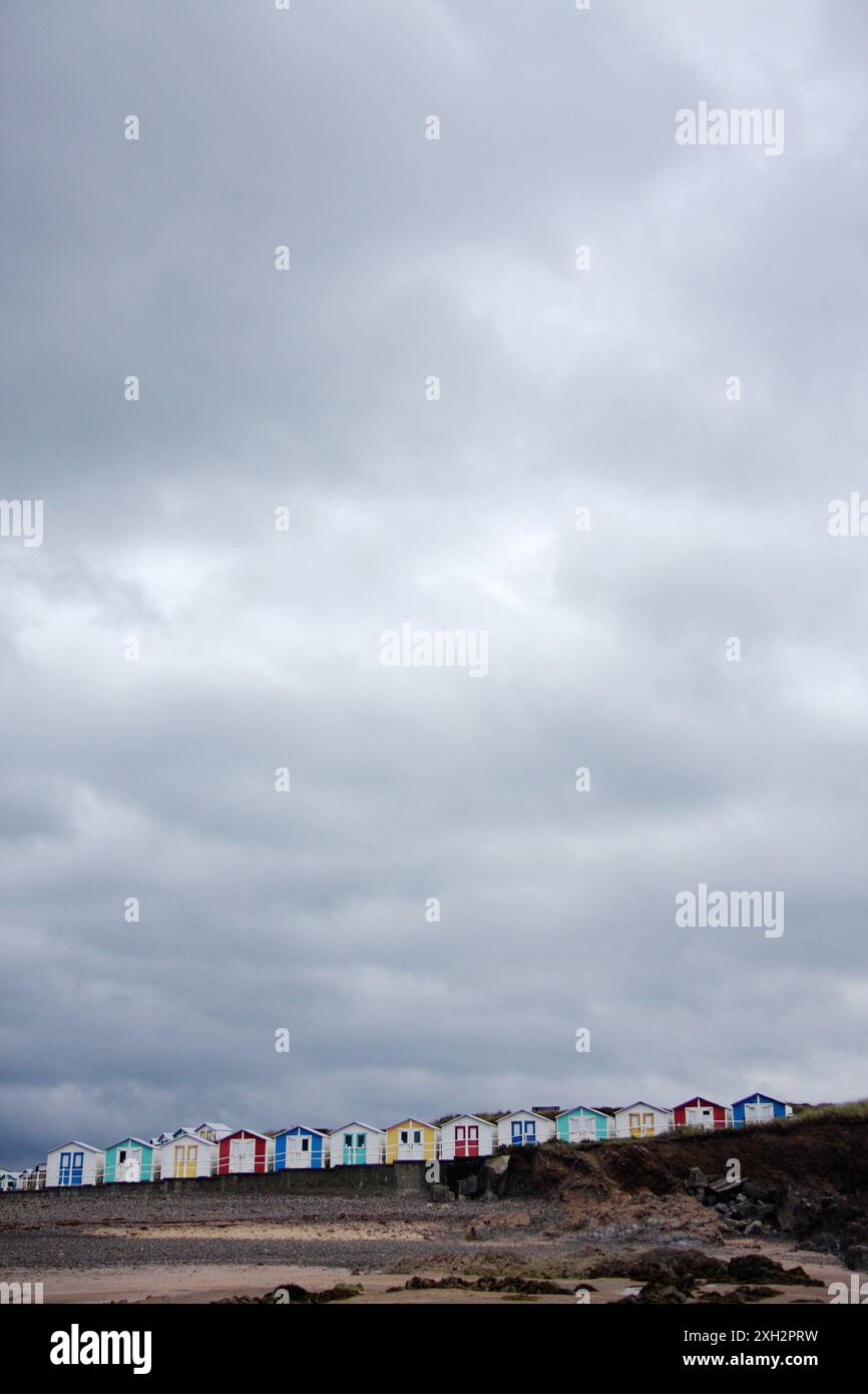 Beach huts at British seaside under grey cloudy sky Stock Photo - Alamy