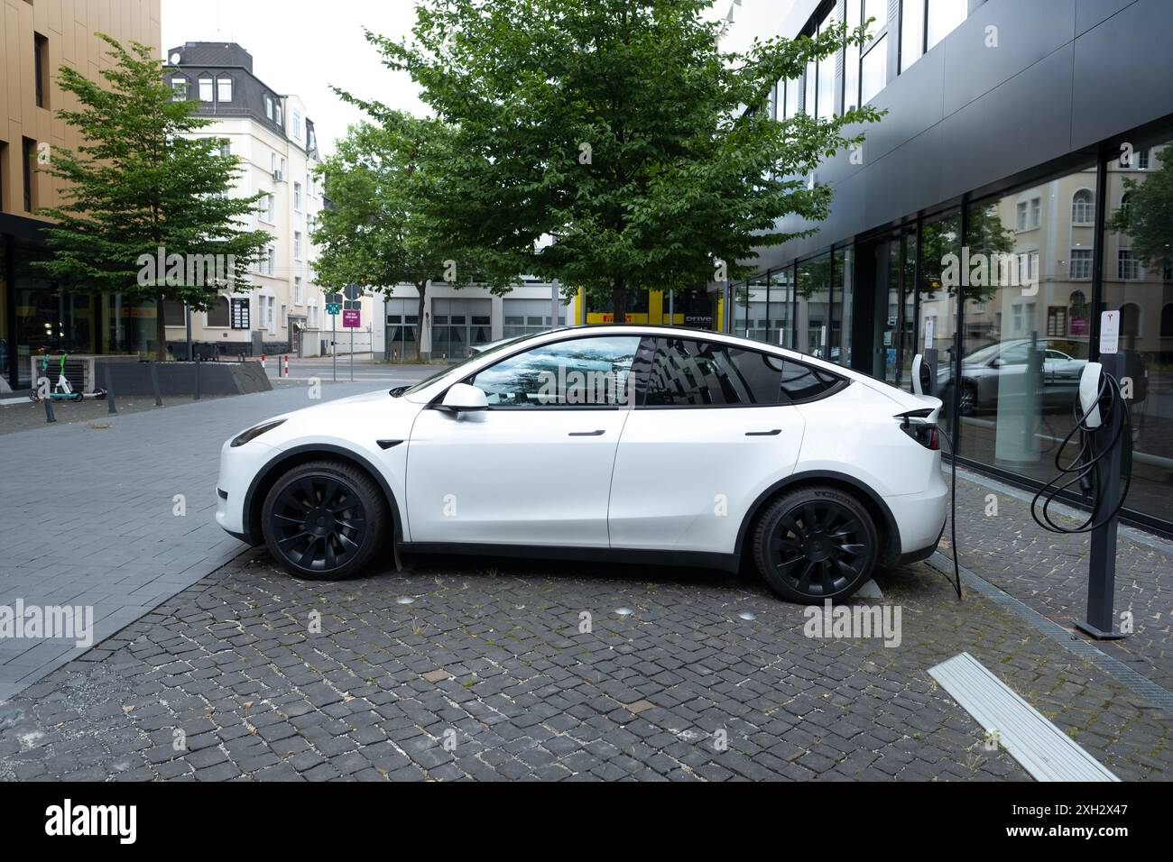 white Tesla Model y car charging on street, innovative electric car ...