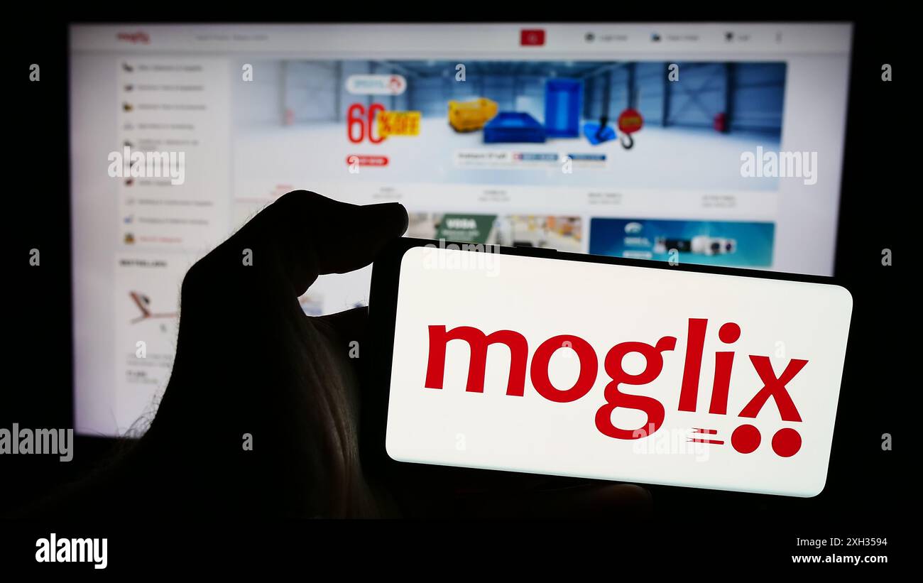 Person holding smartphone with logo of e-commerce company Mogli Labs ...