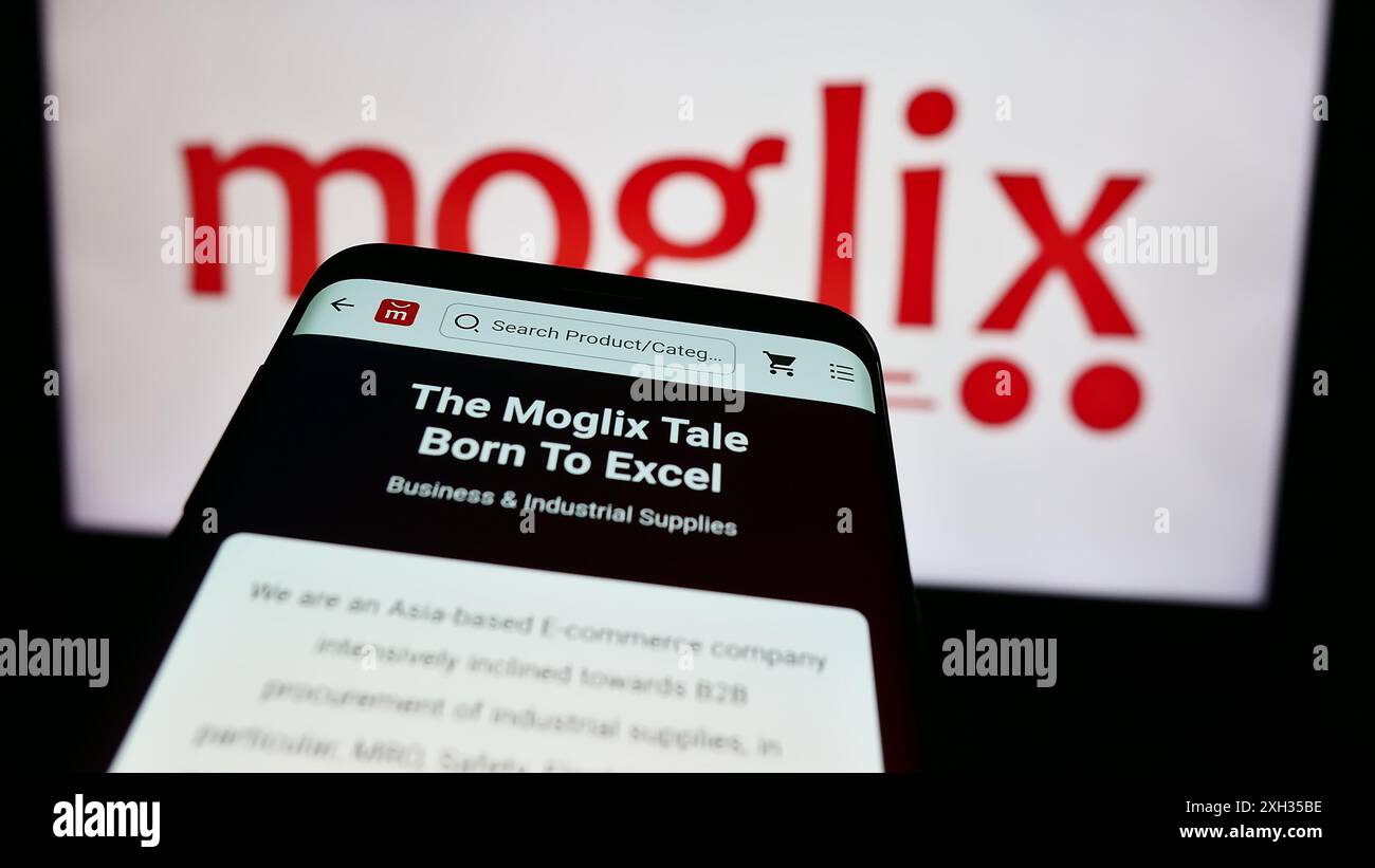 Mobile phone with website of e-commerce company Mogli Labs (India) Pvt. Ltd. (Moglix) in front ...
