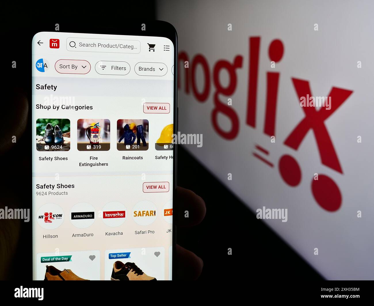 Person holding smartphone with web page of e-commerce company Mogli ...