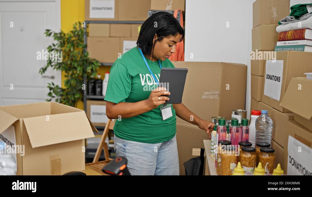 Hispanic woman volunteers sorting donations in a warehouse Stock Photo ...