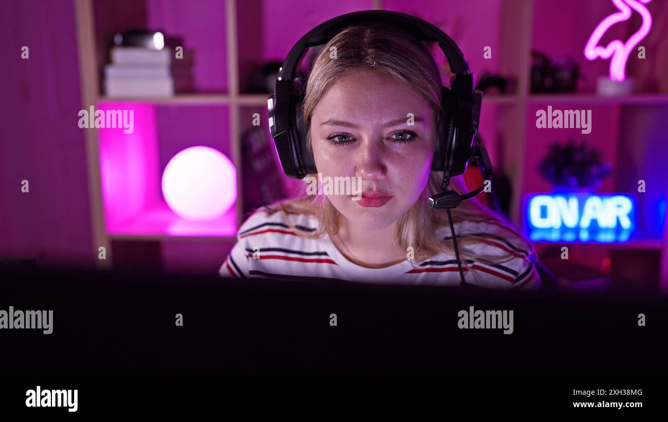 Portrait of a focused young woman gaming at home, with vibrant lighting ...