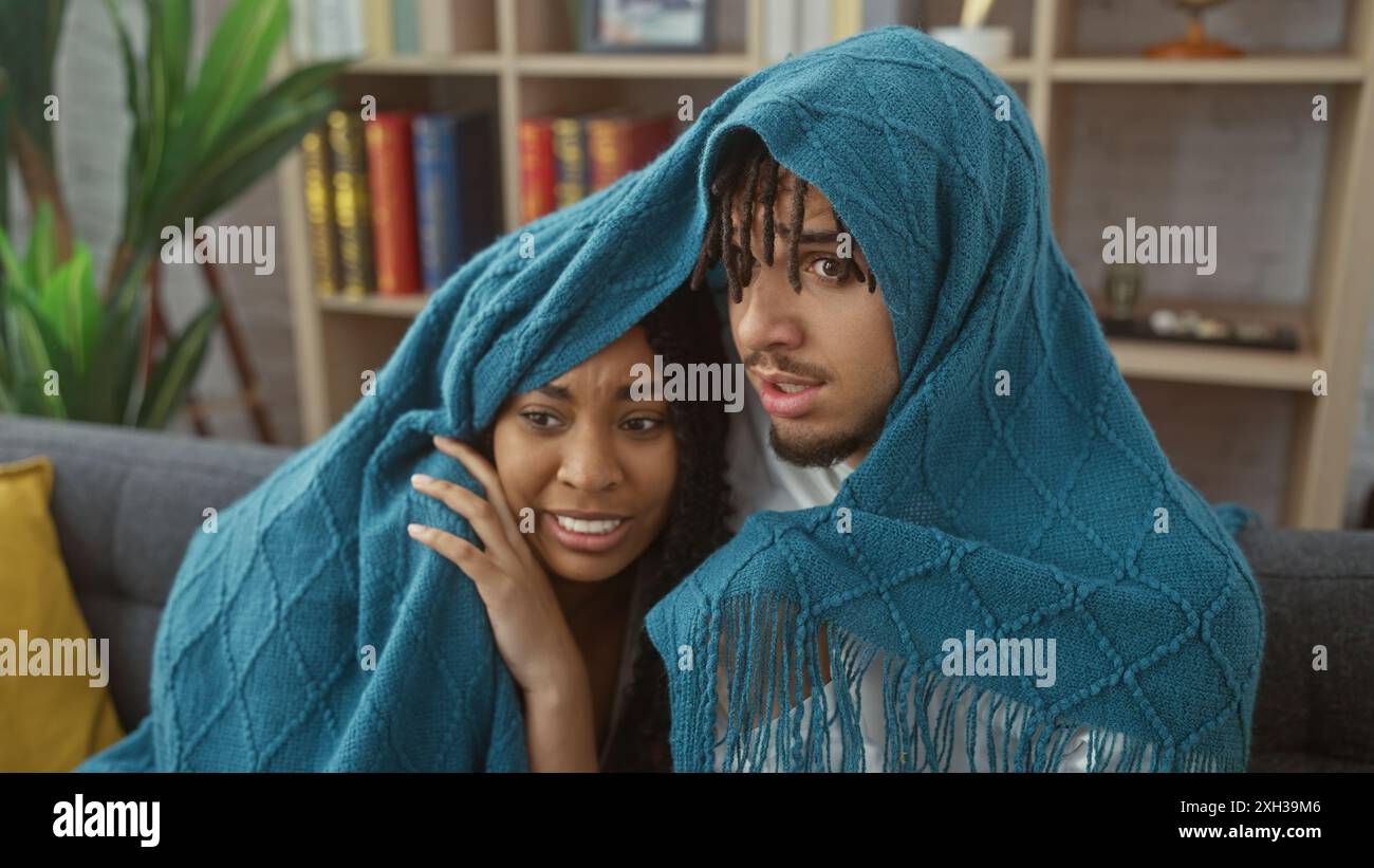 A man and woman wrapped in a blanket, sharing an intimate moment in a ...